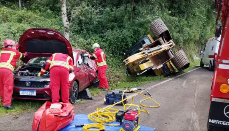 Retroescavadeira cai de caminhão e atinge carro na BR-116